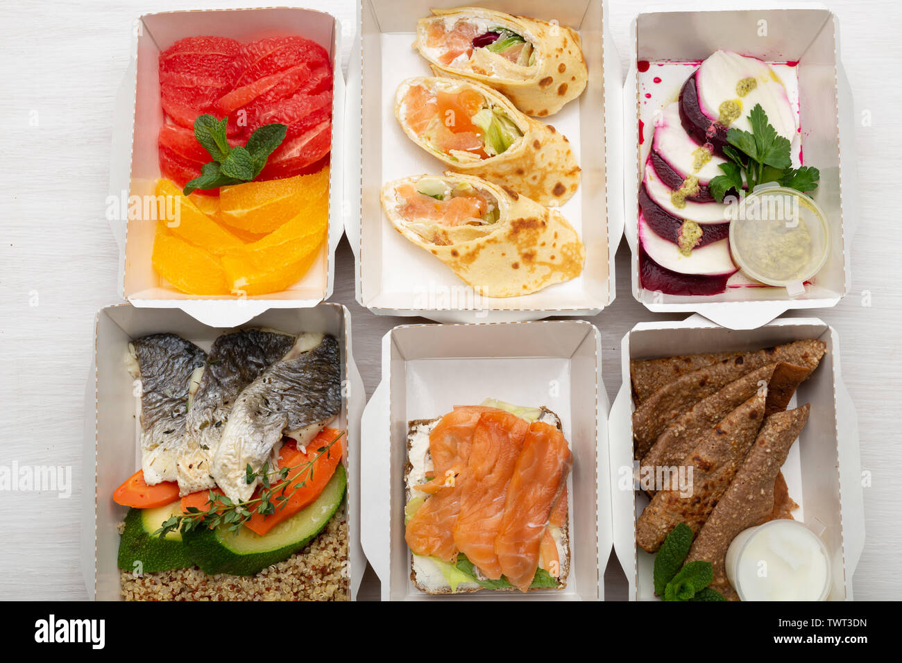 Set of healthy meals for the day in lunch boxes stands on a white table ...