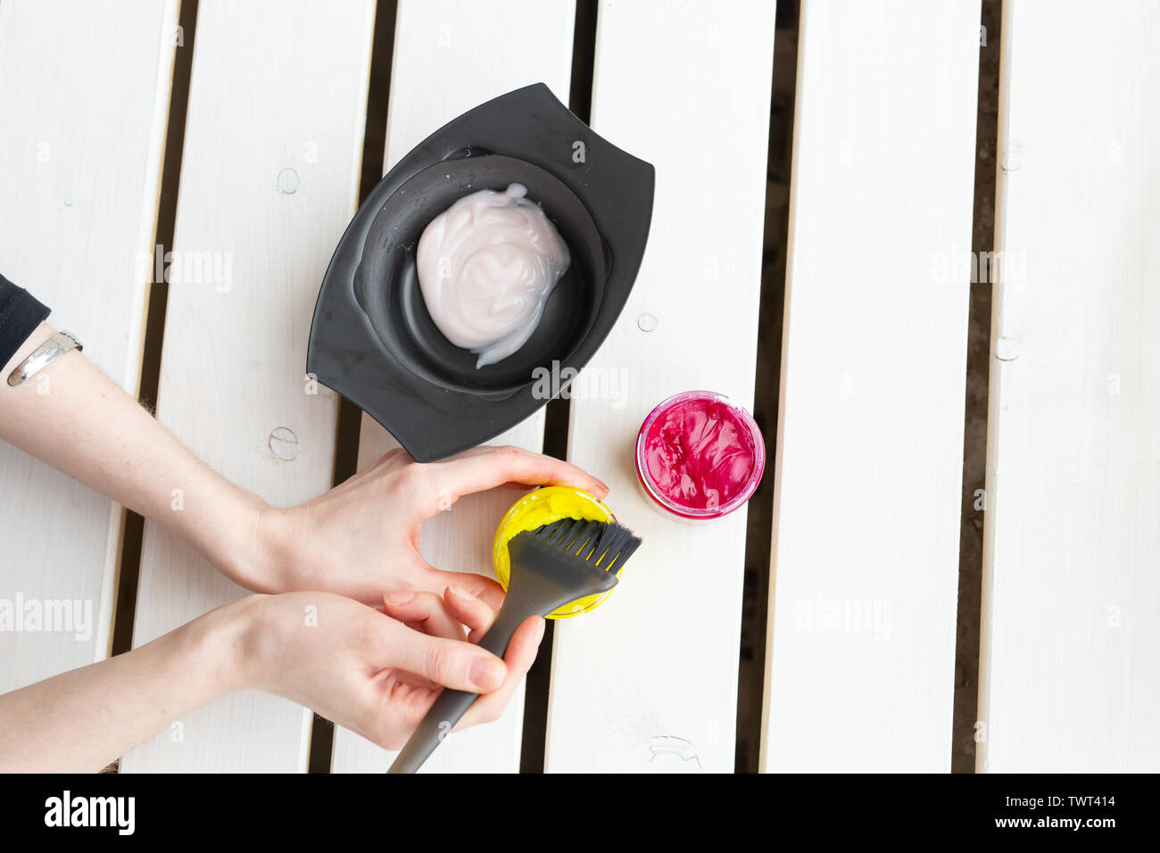 Coloring and hair stylist concept - hands of hairdresser is mixing a ...