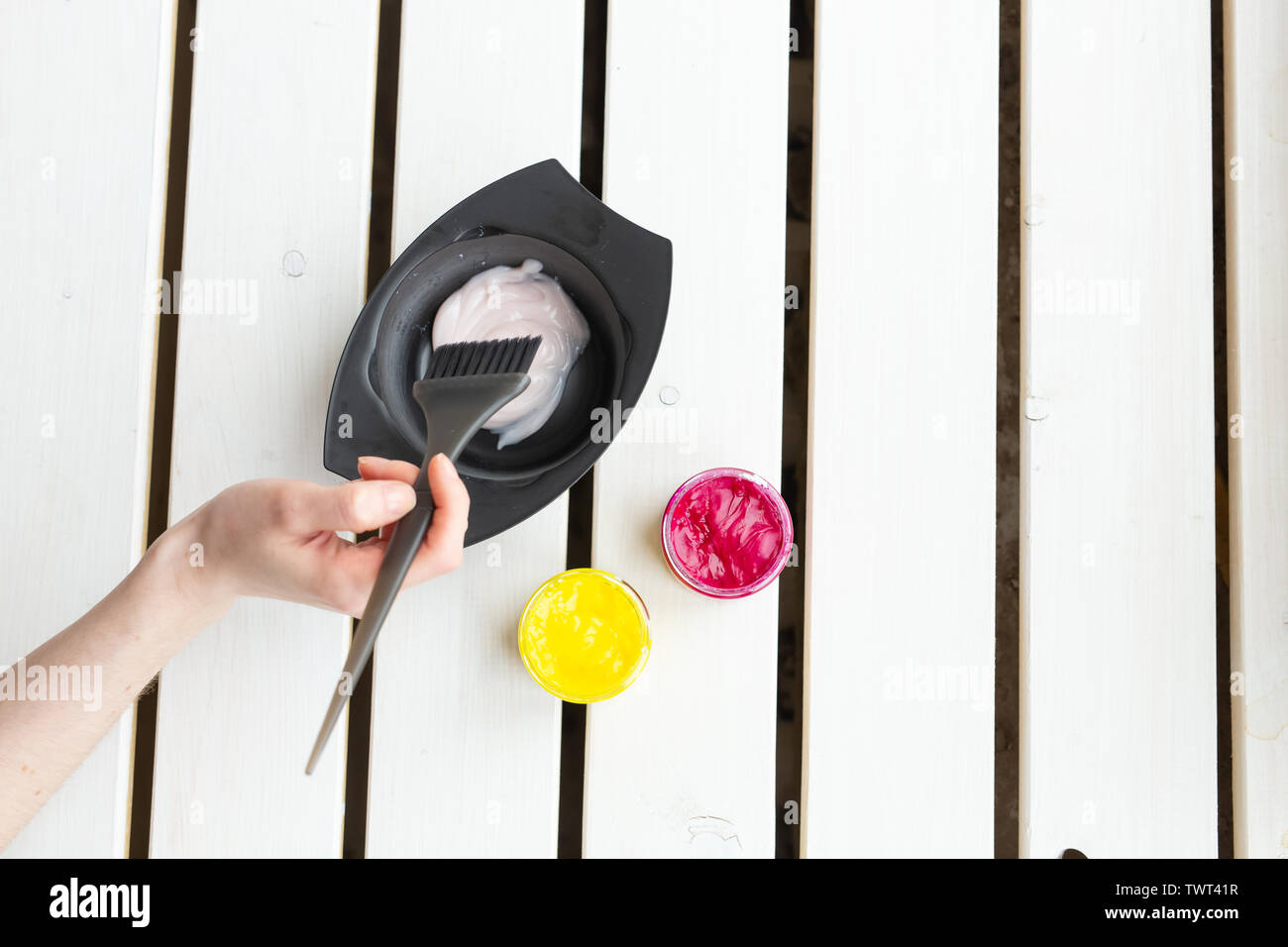 Coloring and hair stylist concept - hands of hairdresser is mixing a ...