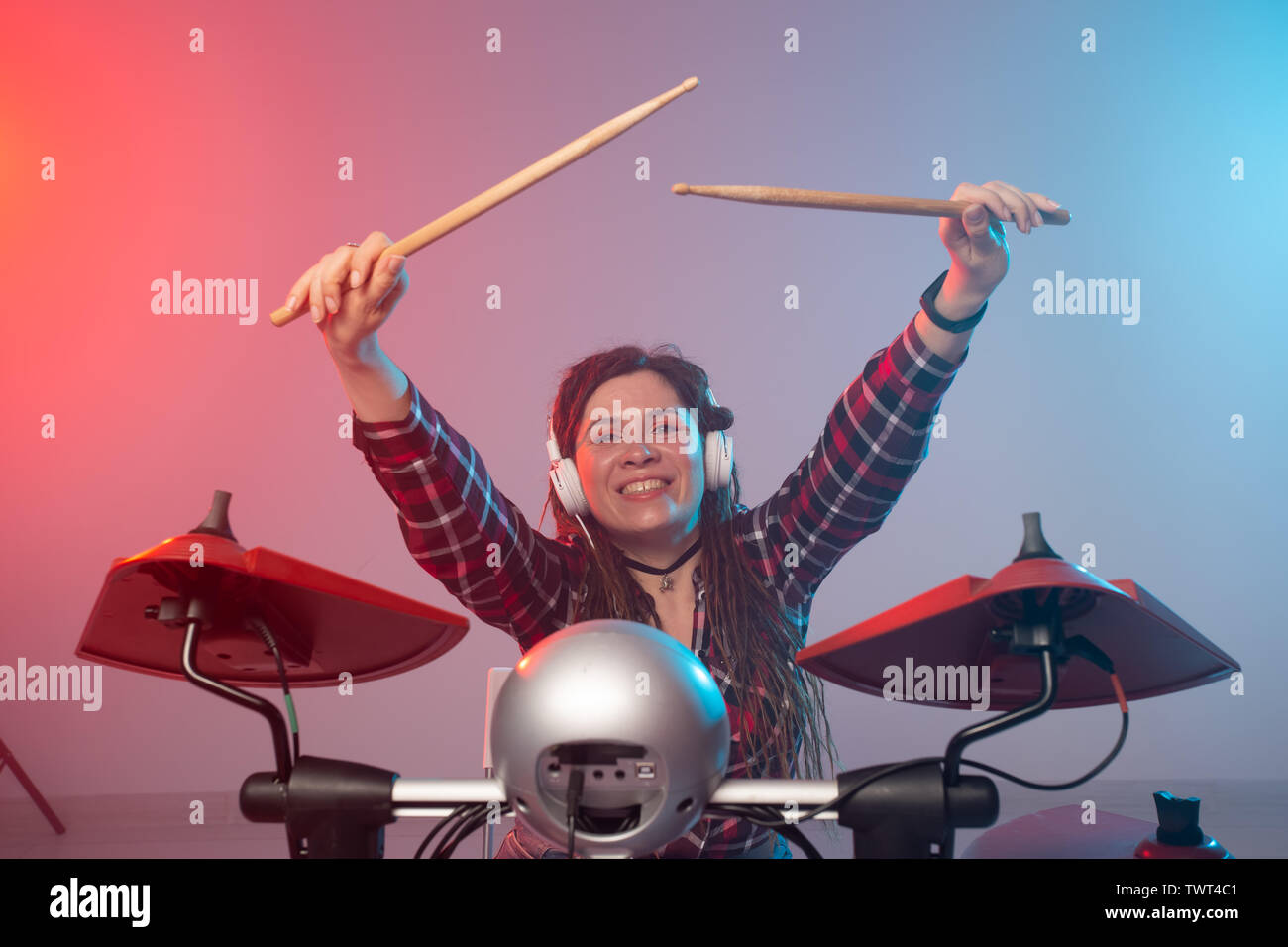 Music and hobby concept - woman drummer playing the electronic drum set ...