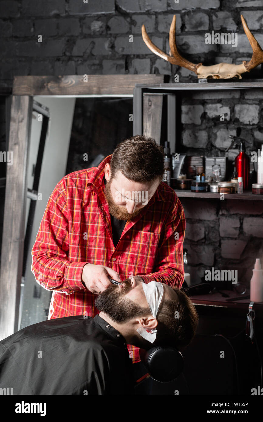 Beard cutting, face care. Barber work with clipper machine in ...