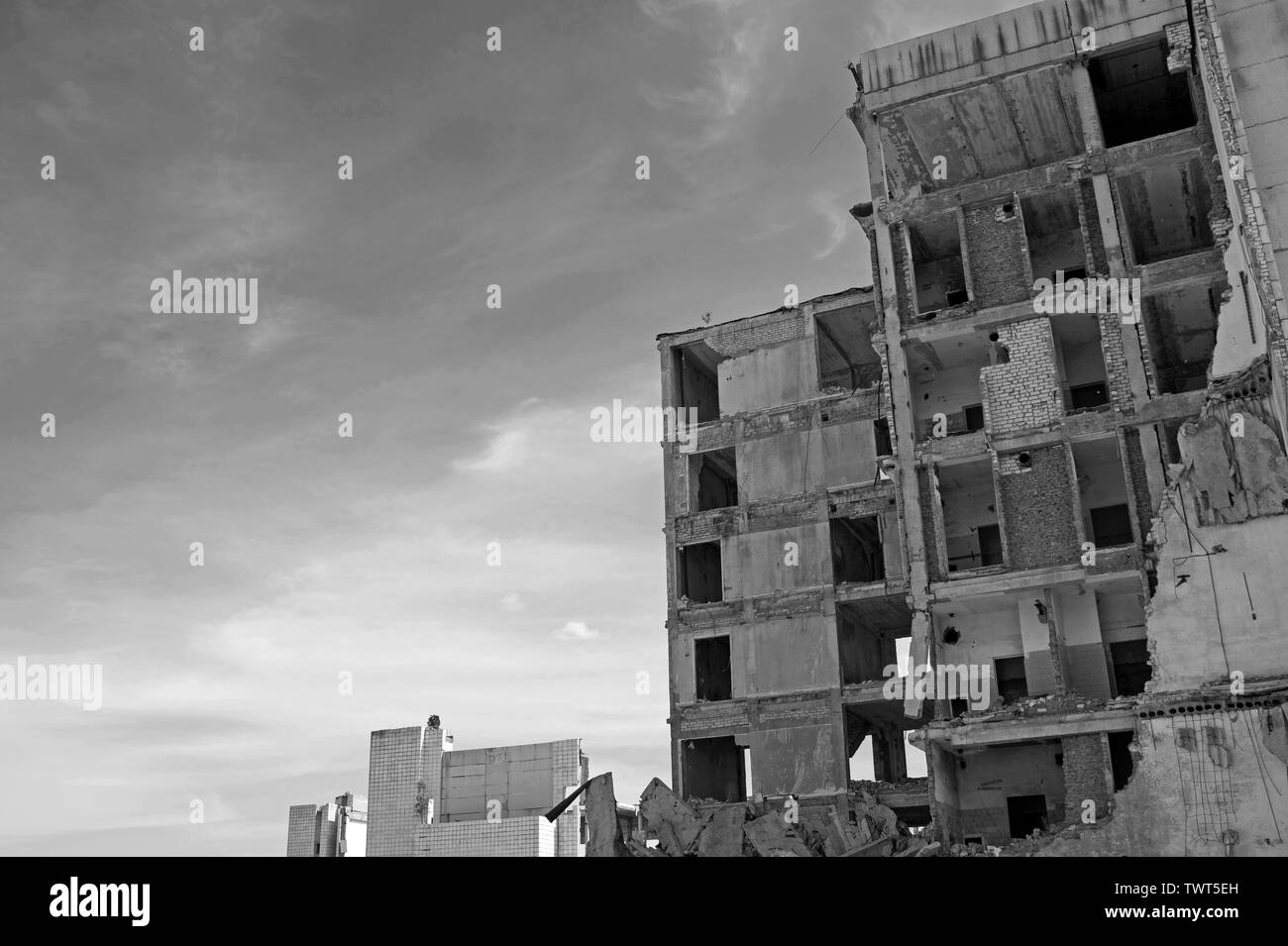 The remains of a destroyed concrete building against the sky. Space for ...