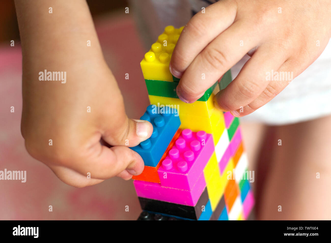 Small hands of the child collects the bright plastic colored Designer ...