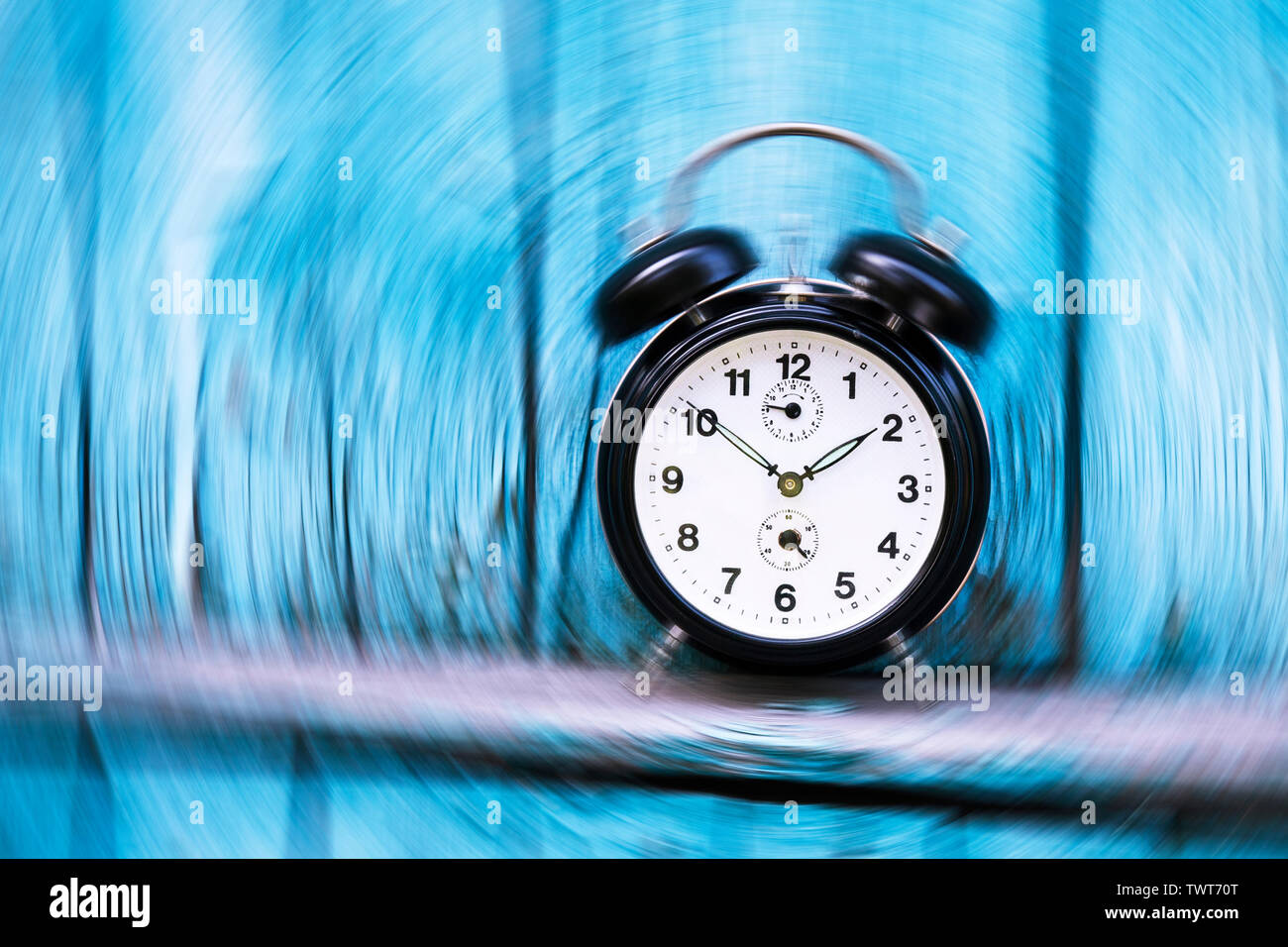 Vintage round shaped alarm clock on the background with blurred motion ...