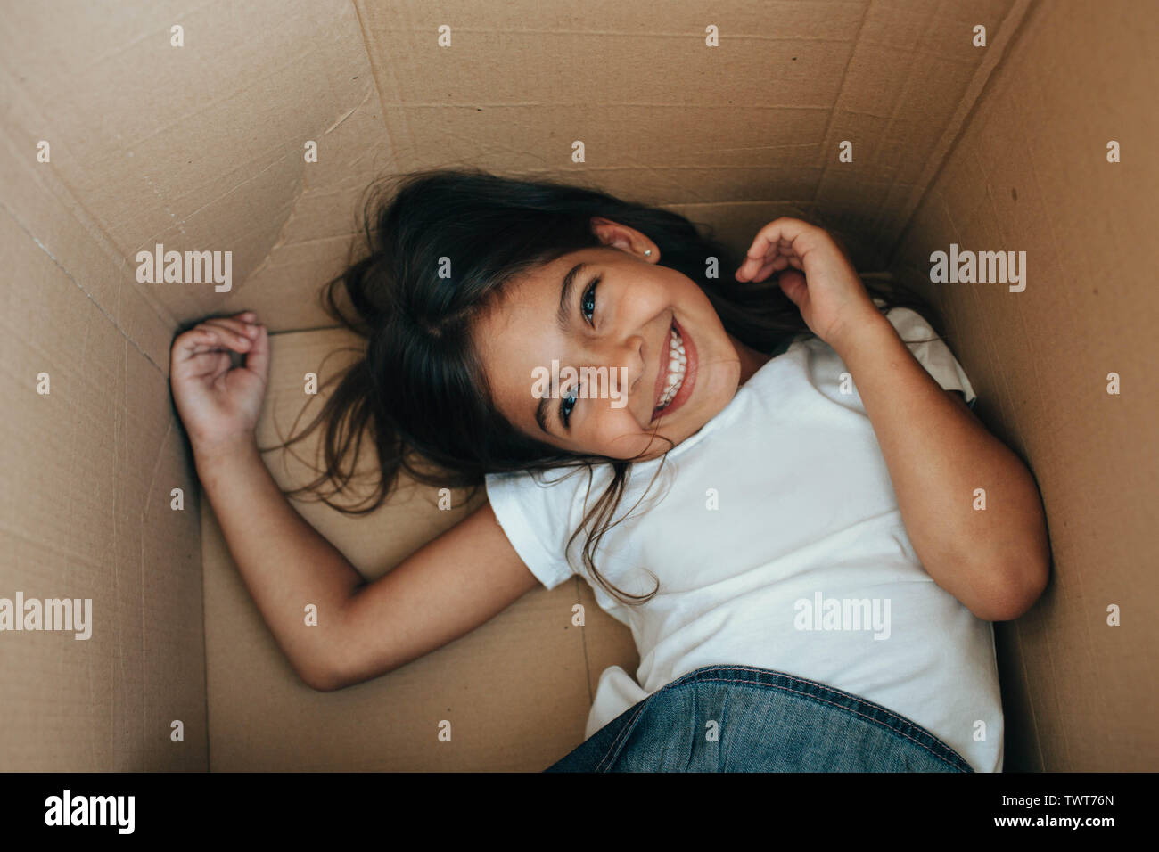 little girl playing inside a cardboard box, into her new house Stock ...