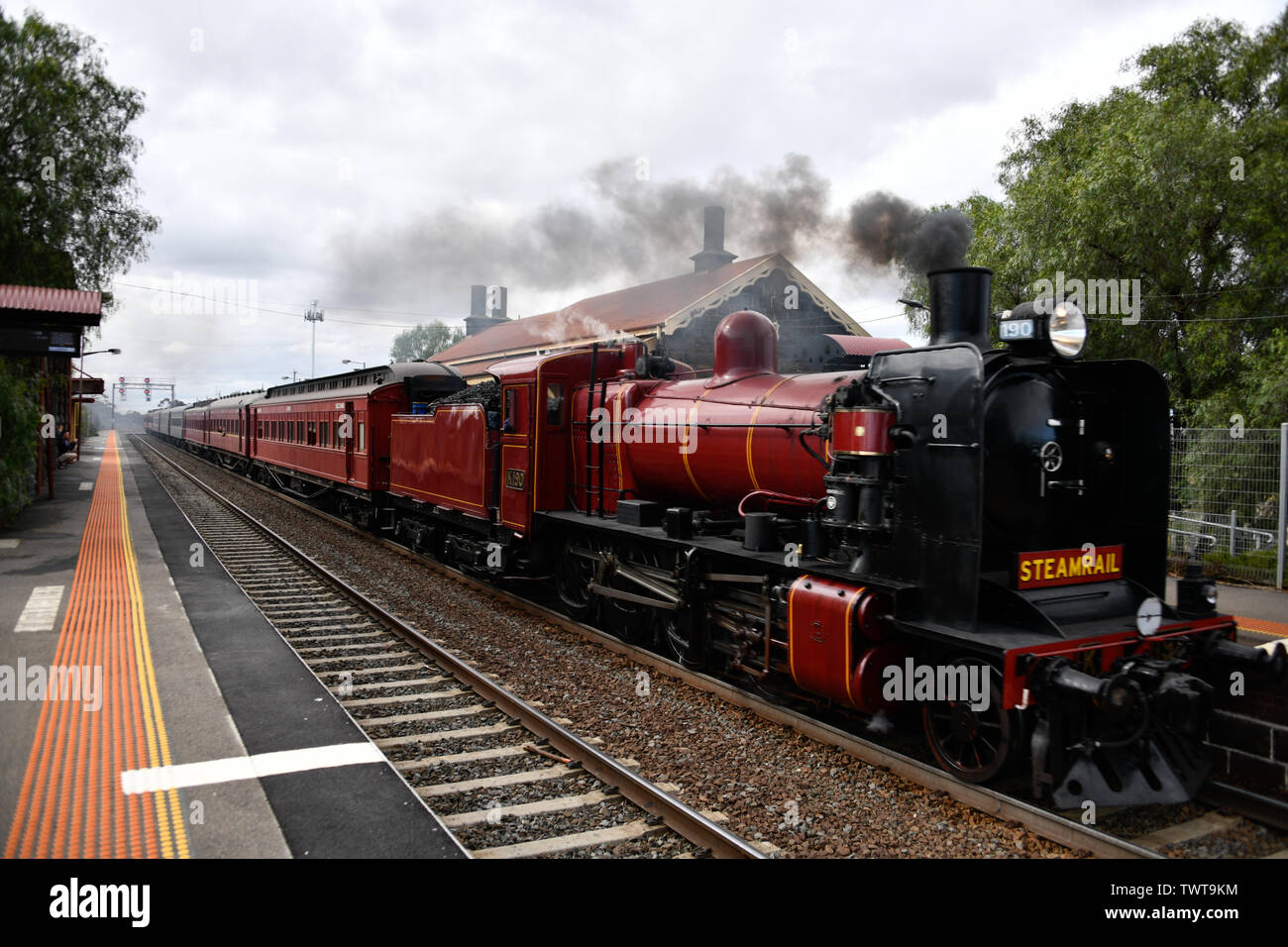 K190 Red Steam Train Racing through Old Train Station Stock Photo - Alamy