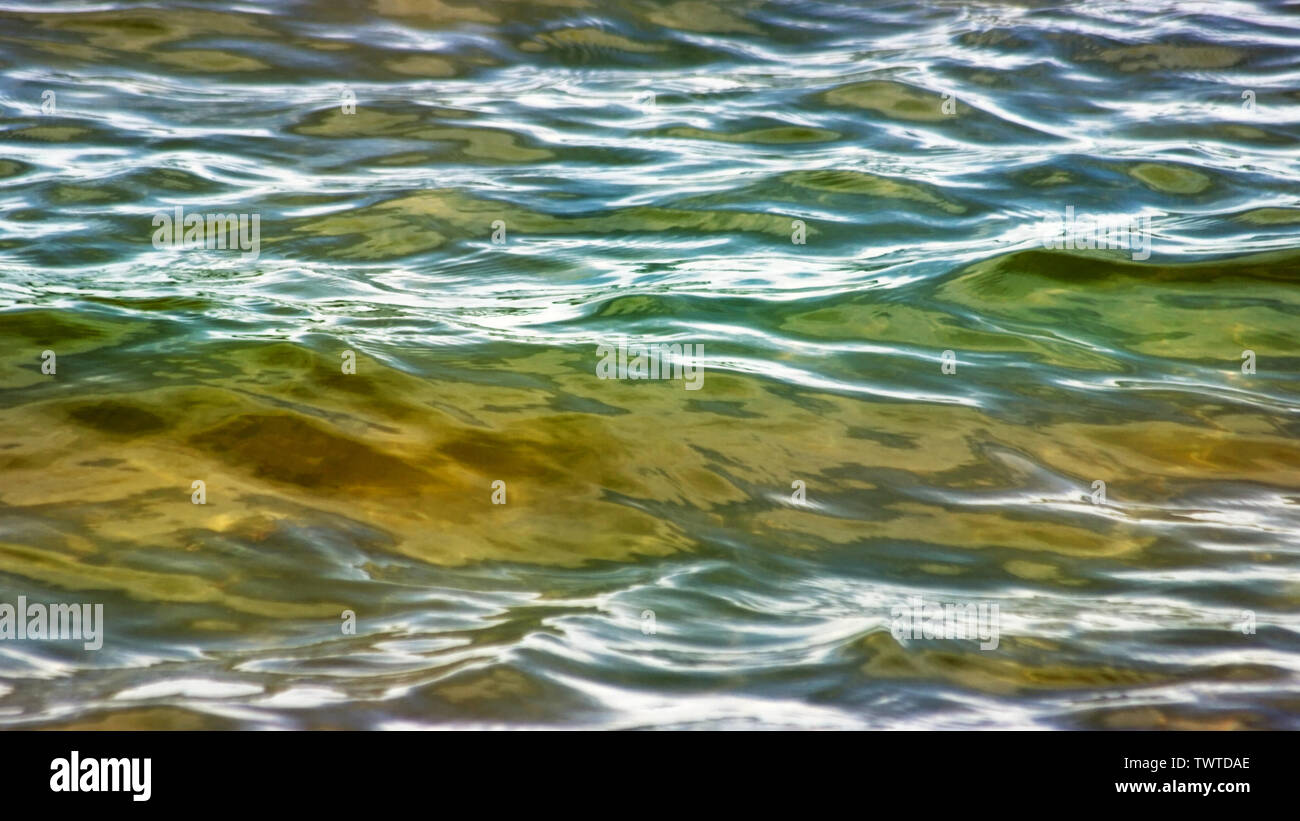 Beautiful rippling lake waters of green blue and gold Stock Photo - Alamy