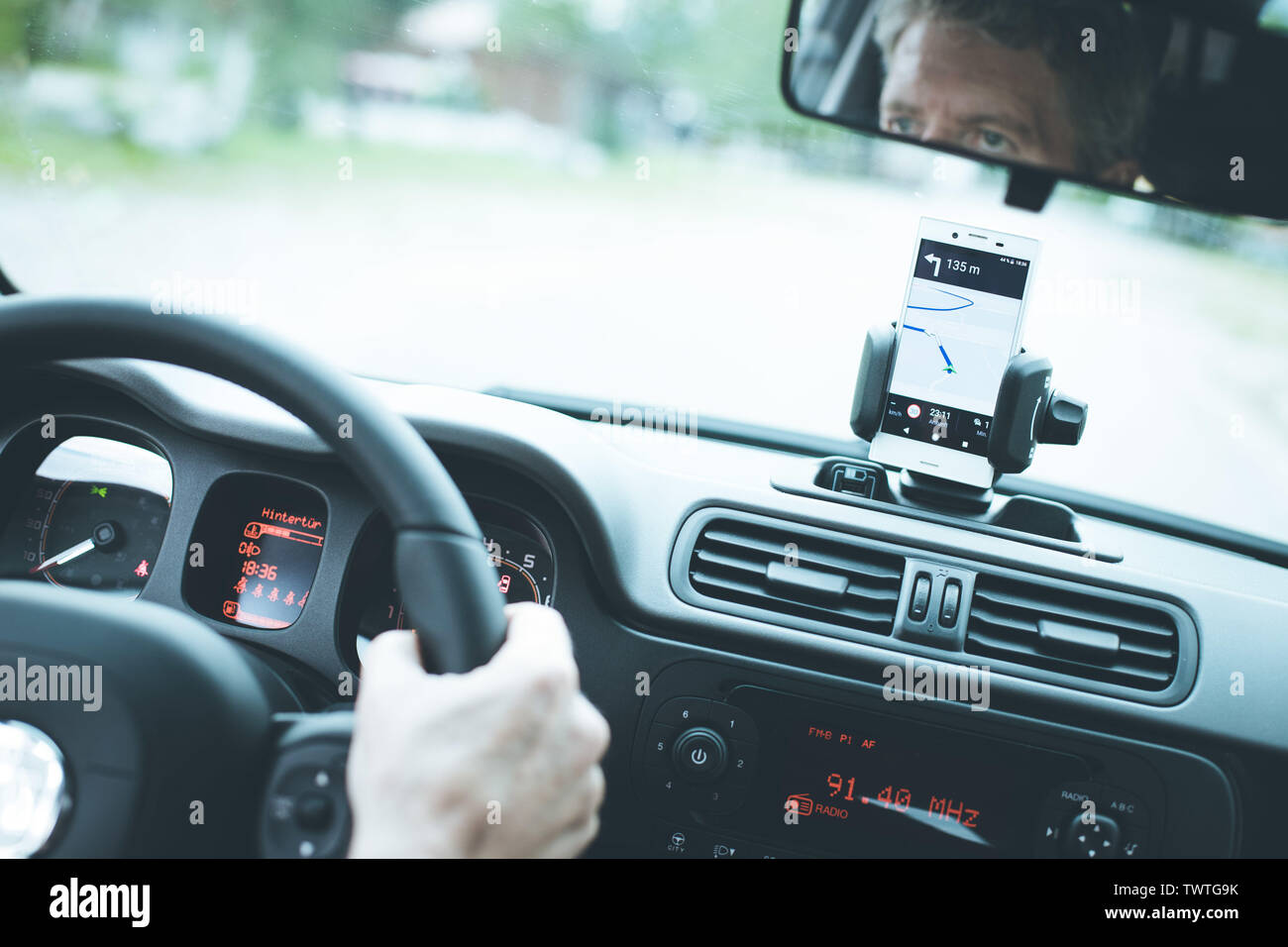 Car dashboard with smartphone used as navigation device, bright and ...