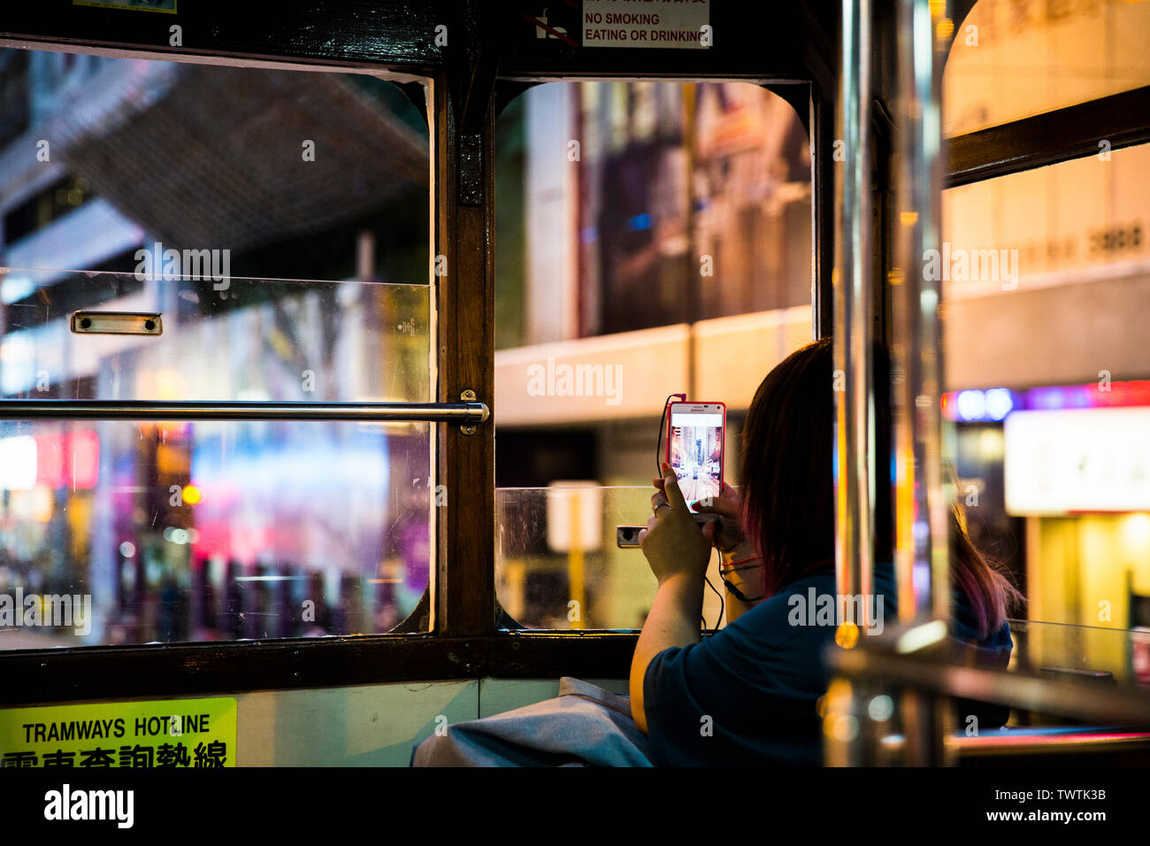 Woman taking a photo from the window of a ding ding. Hong Kong Stock ...
