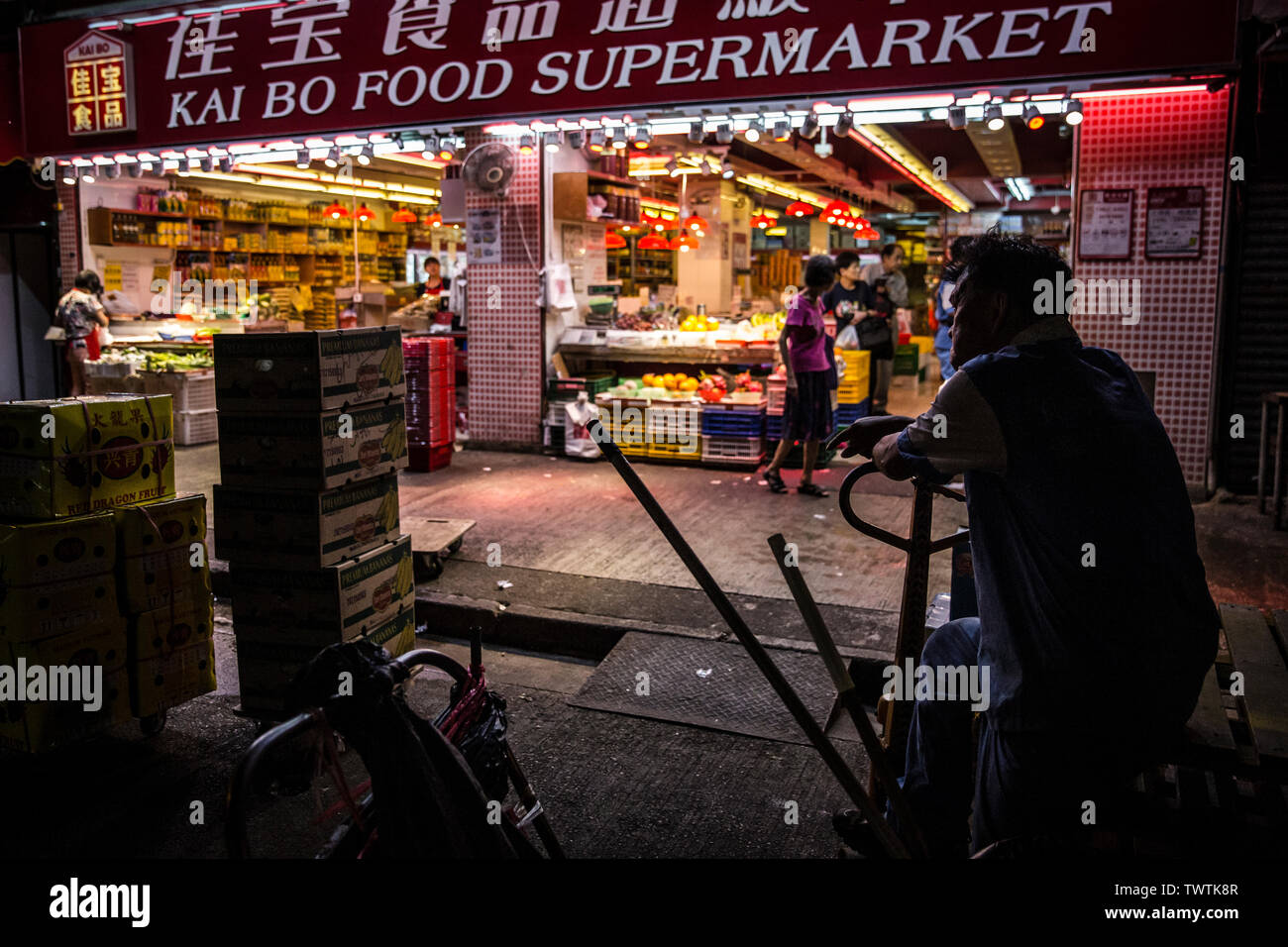 Worker in front of Kai Bo Food Supermarket. Hong Kong Stock Photo - Alamy