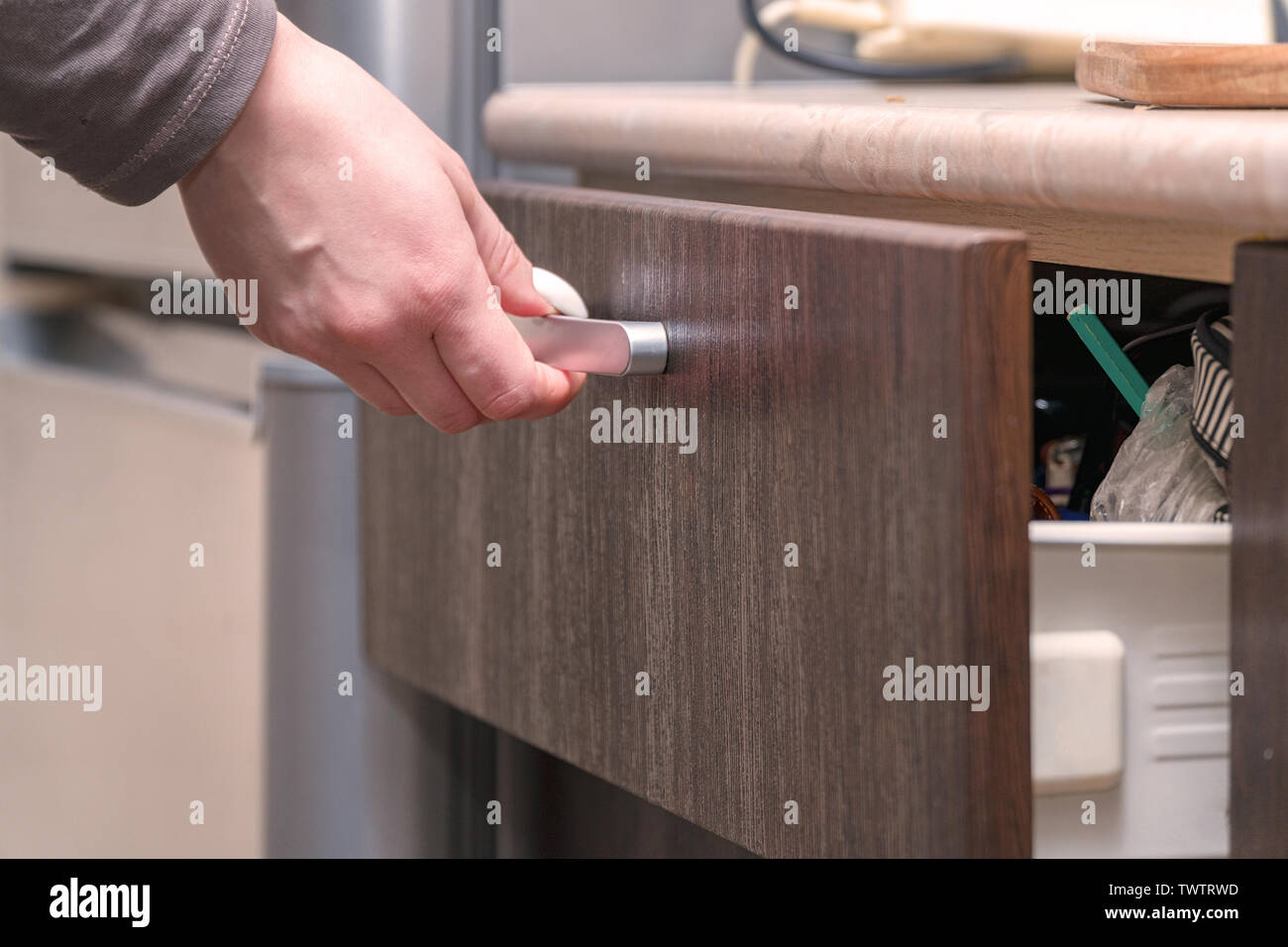 Womans hand opens the drawer of the table Stock Photo - Alamy