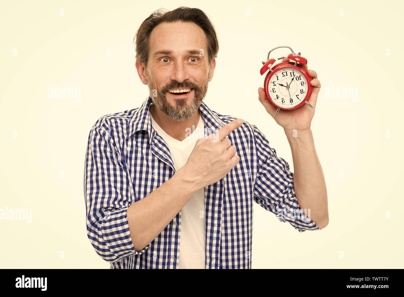Please observe time. Mature man pointing finger at alarm clock. Mature ...