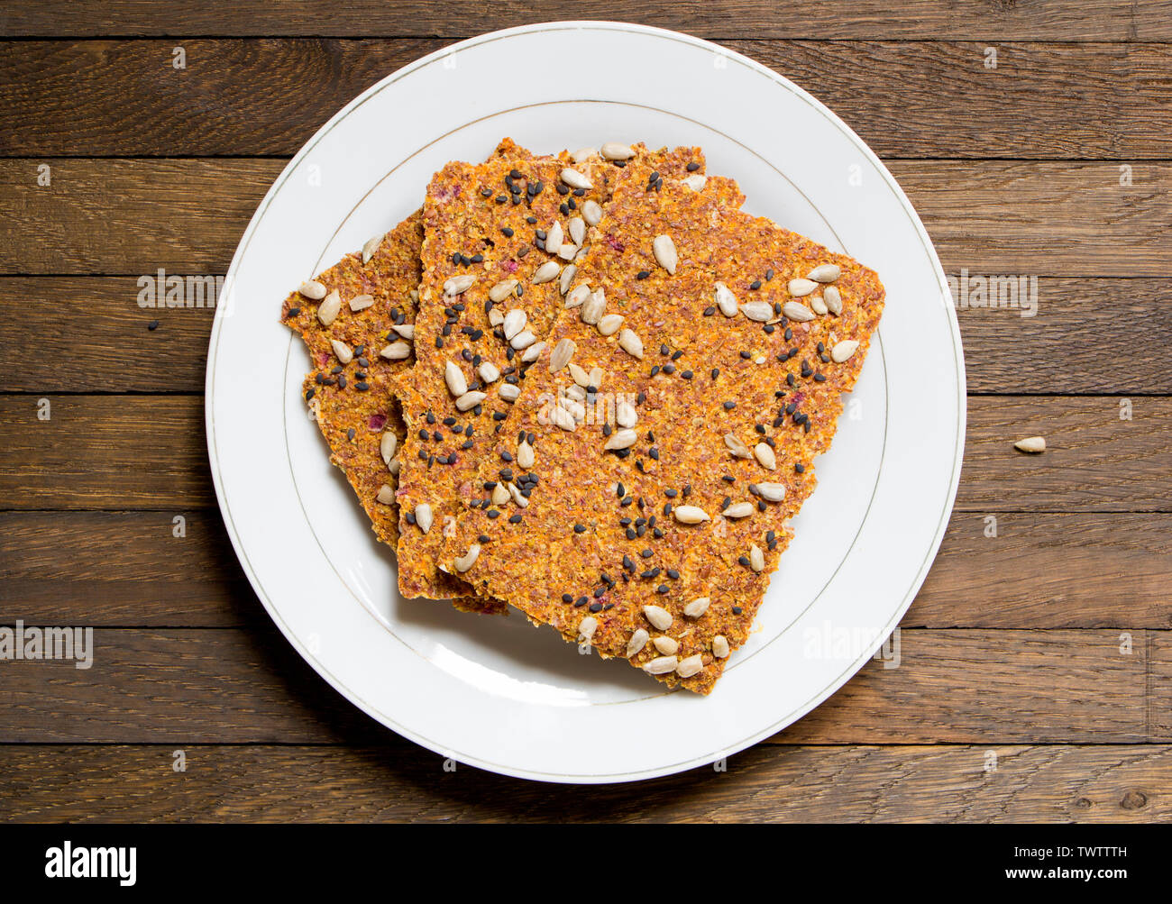 Dehydrated vegan raw bread loaves on white dish on wooden table with ...