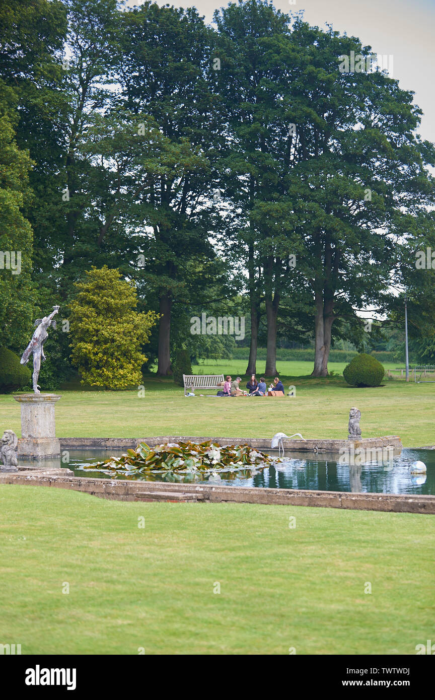 A Family enjoying a picnic in the outdoors during the summer in front ...