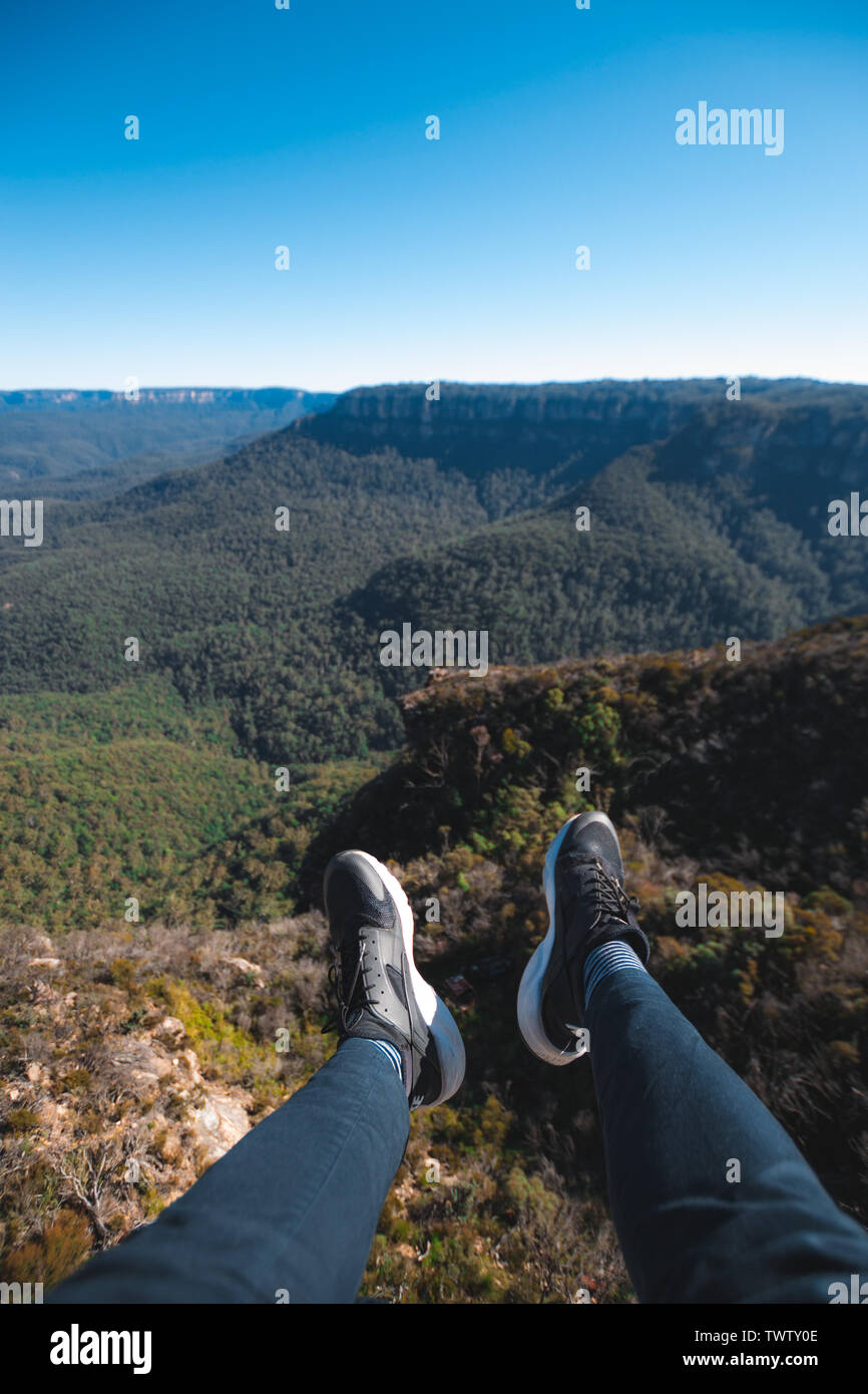 First person view of two legs overlooking a valley of forests Stock ...