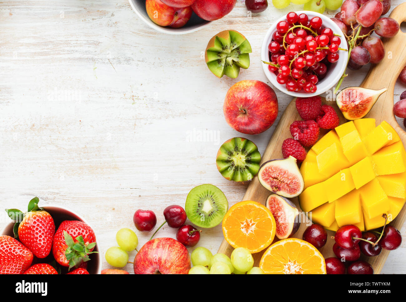 Colorful fruits background, cut mango, strawberries raspberries oranges ...