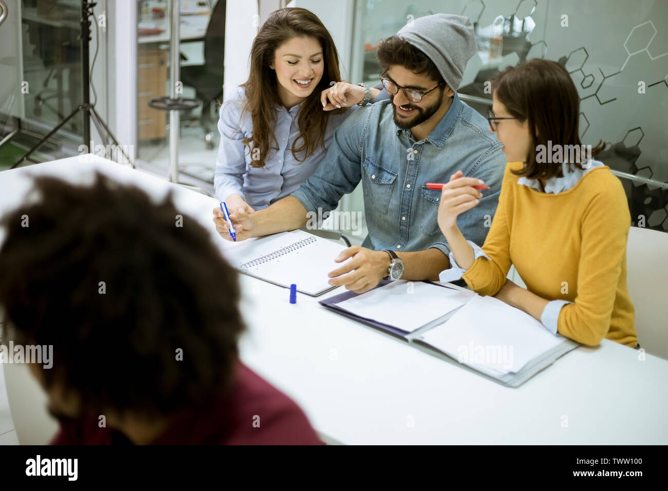 Young students sitting by the desk in the classroom Stock Photo - Alamy