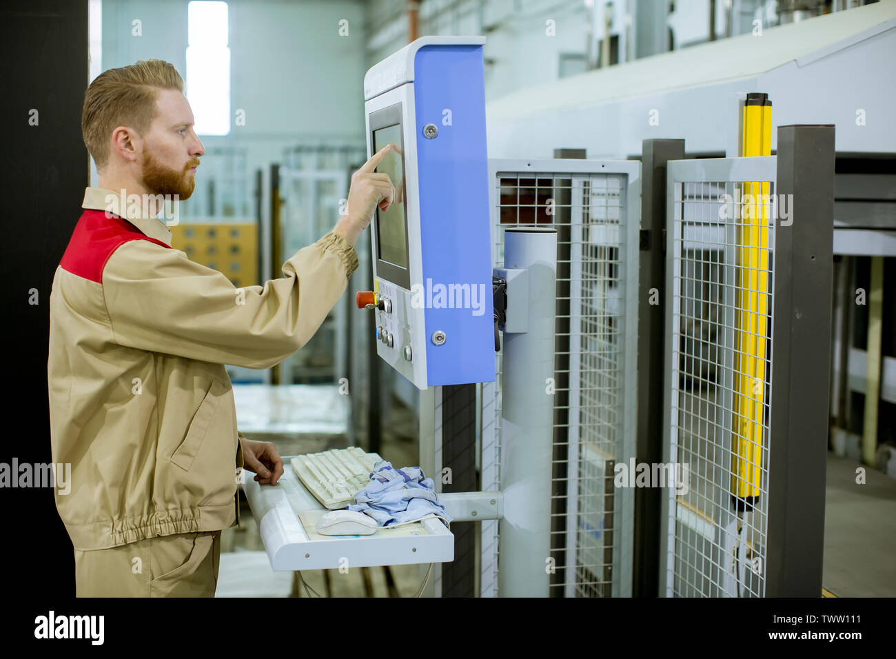 Handsome male operator presses the button on the control panel at the ...