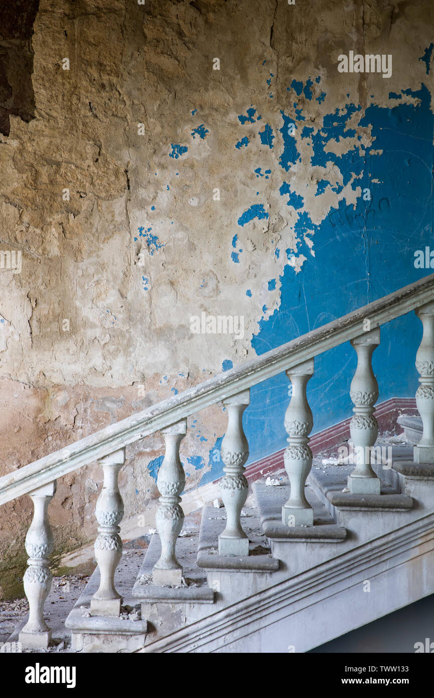 Side view at old staircase in interior of an abandoned and ruined ...
