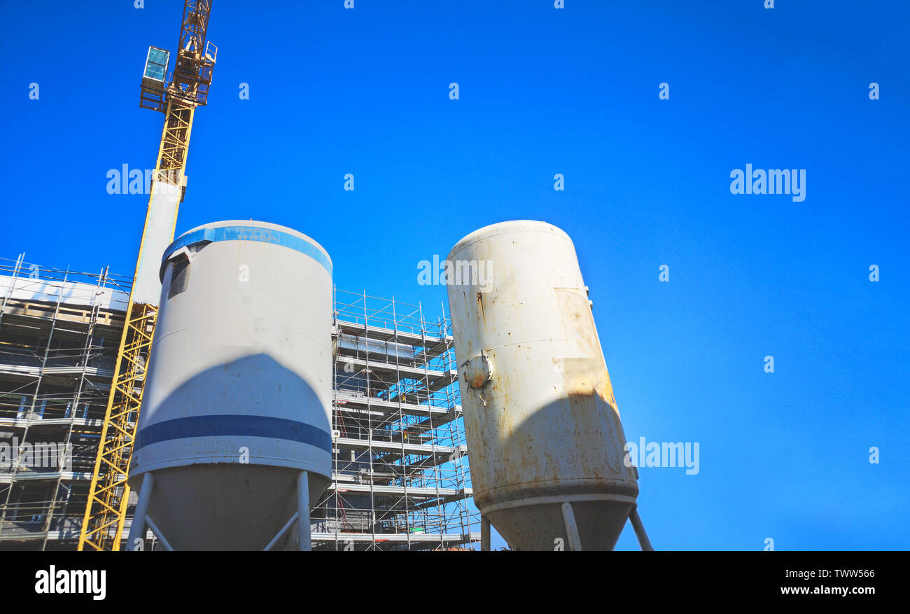 mortar silos at construction site with crane and blue sky Stock Photo ...