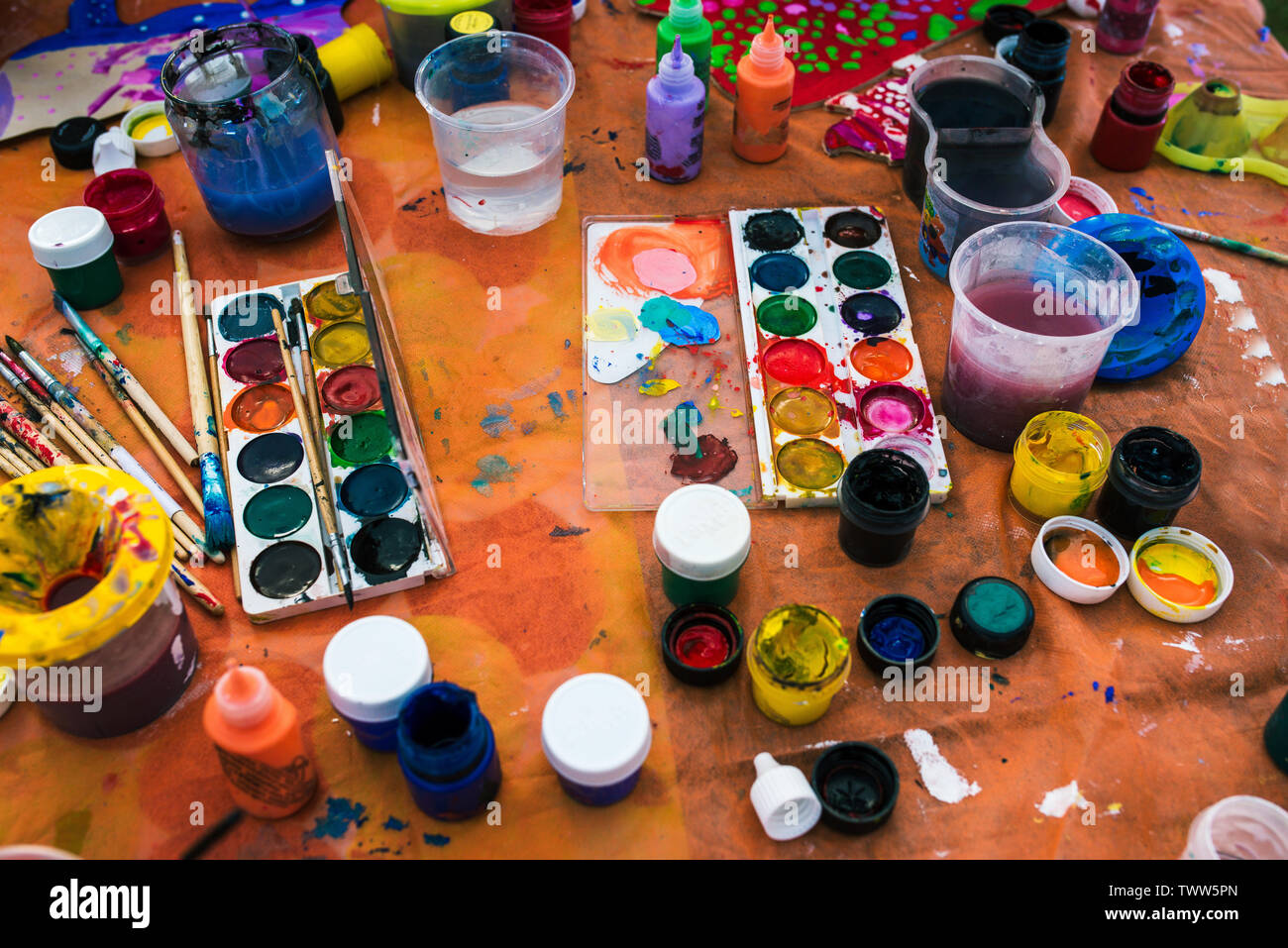 Table for drawing on which are brushes, paints, cans of water and a ...