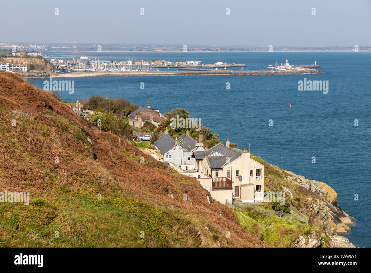 Houses in cliff with Howth Pier in background, Howth, Dublin, Ireland ...