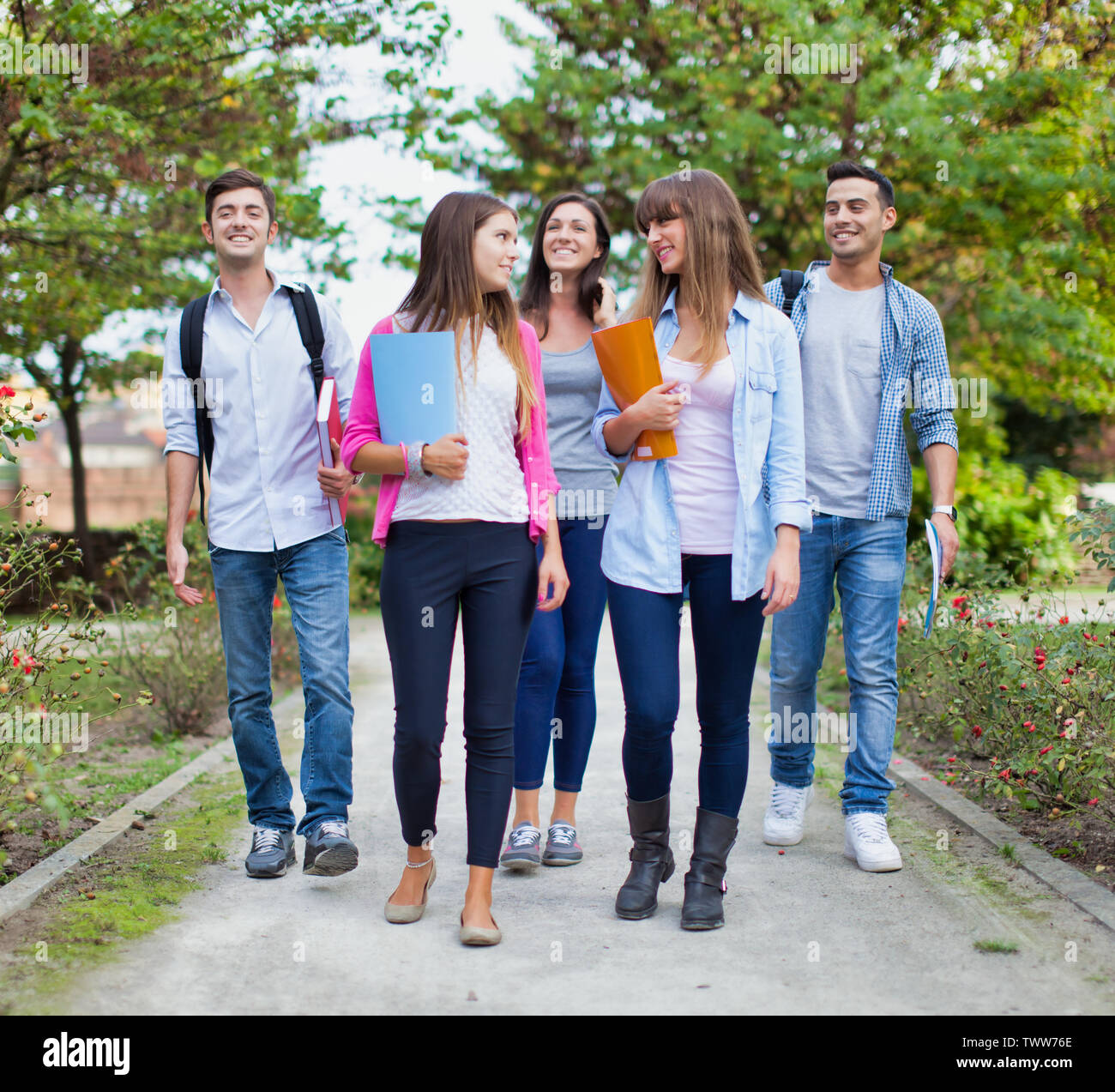Outdoor portrait of a group of students walking in the school park ...