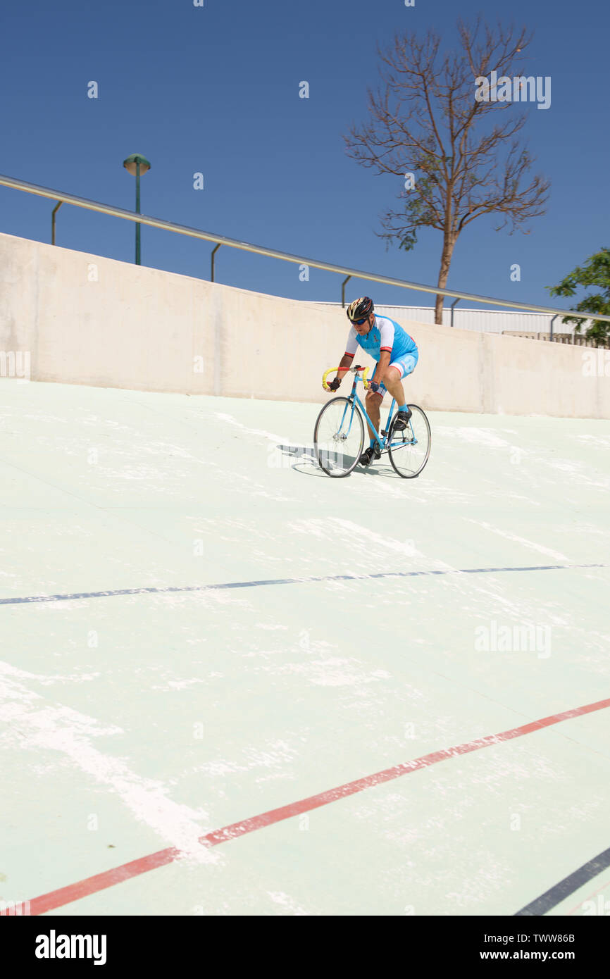 Senior citizen riding a bicycle around a velodrome Stock Photo - Alamy