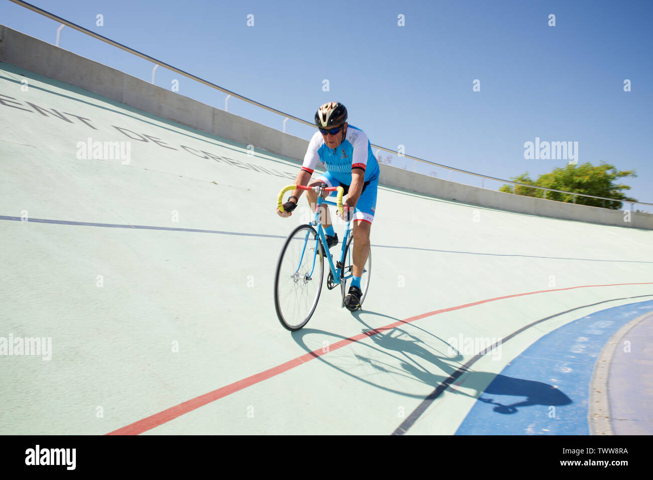 Senior citizen riding a bicycle around a velodrome Stock Photo - Alamy