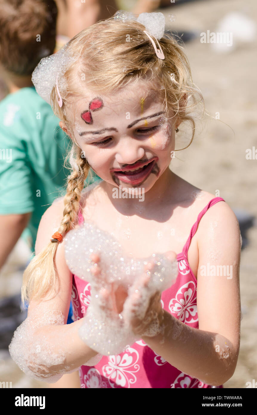 happy girl enjoying foam party Stock Photo - Alamy