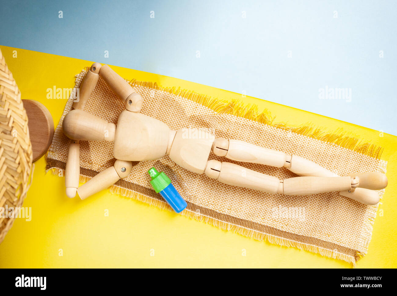 Wooden dummy on yellow as sand beach and blue as water. Concept travel ...