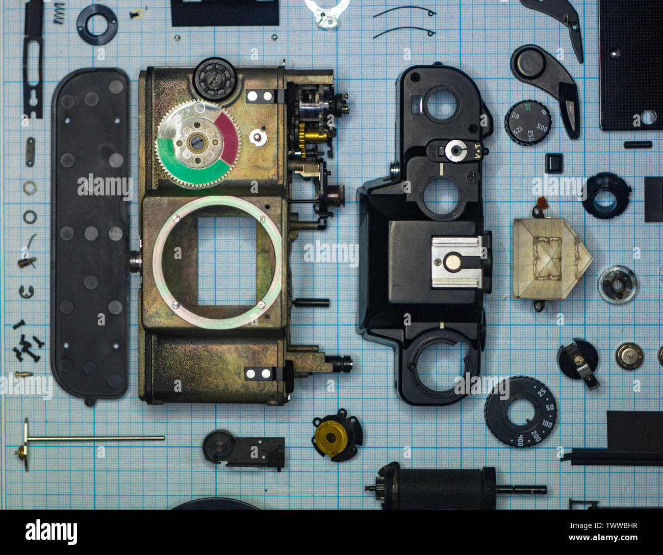parts are completely disassembled old retro film SLR camera on graph ...