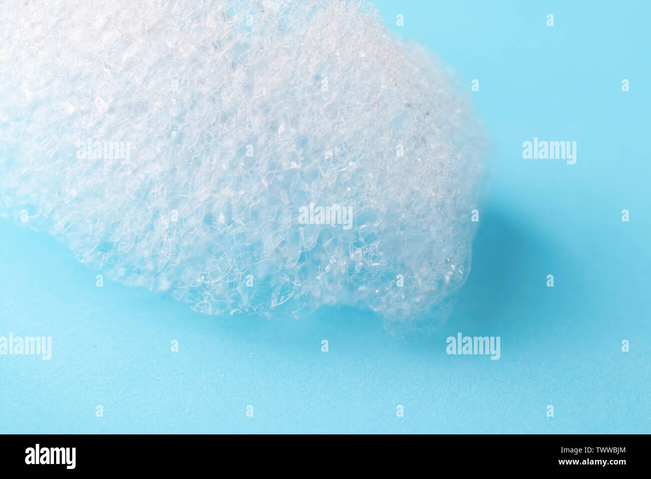 A lump of foam on a blue bright background. Safe environmentally ...