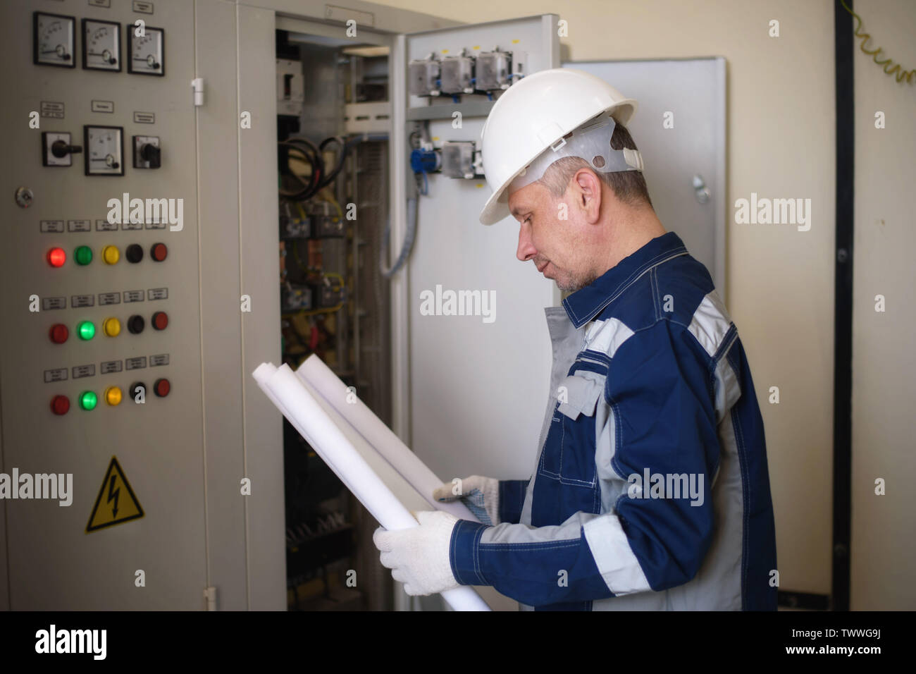 foreman electrician examines the working draft next to the dashboard ...
