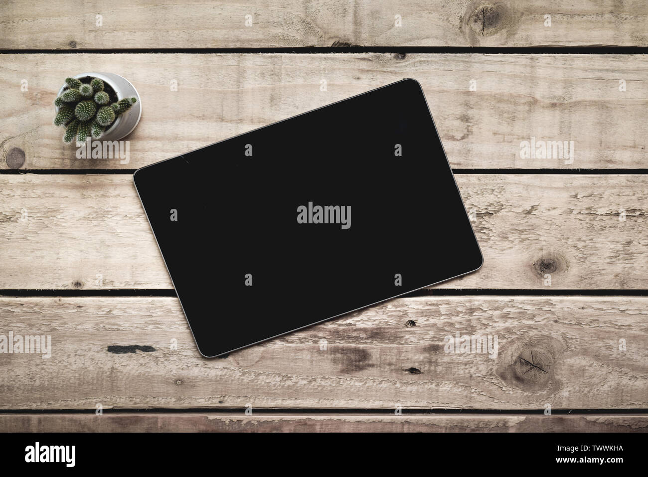 Tablet device with blank empty screen on wooden office desk with copy ...