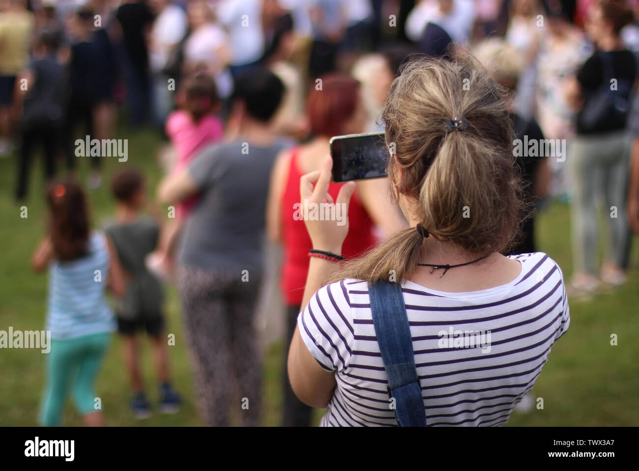 Woman taking photo of live stage performance Stock Photo - Alamy