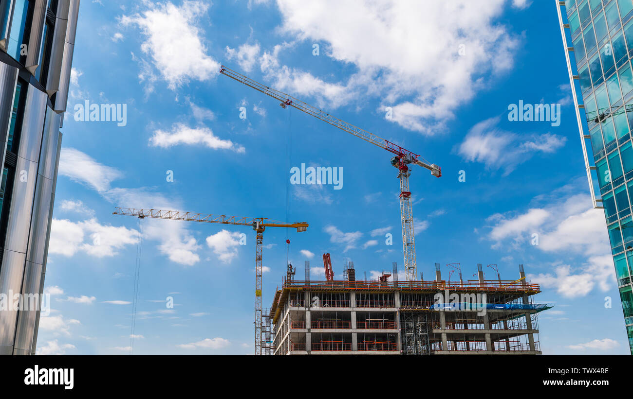 Skyscraper construction. Two tower cranes. Blue sky background. Skyline ...