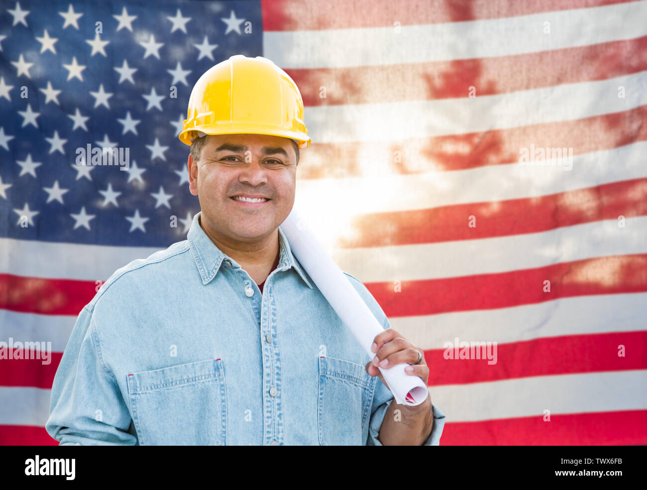 Hispanic Male Contractor with Blueprint Plans Wearing Hard Hat In Front ...