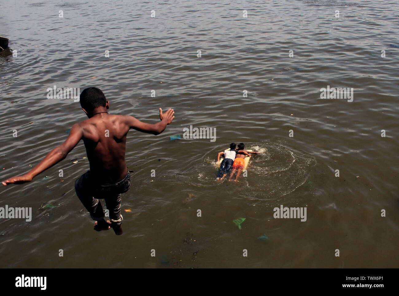 Dhaka, Bangladesh. 23rd June, 2019. Bangladeshi youth dives into ...