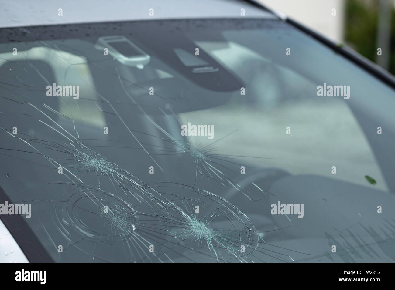 Hail damage to front window after a severe thunderstorm Stock Photo - Alamy