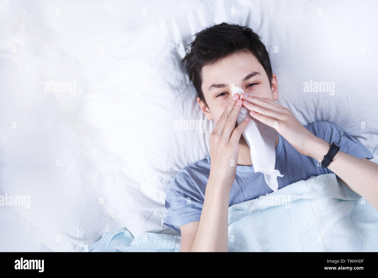 a sick child is a teenager in bed, view from above, in the hands the ...