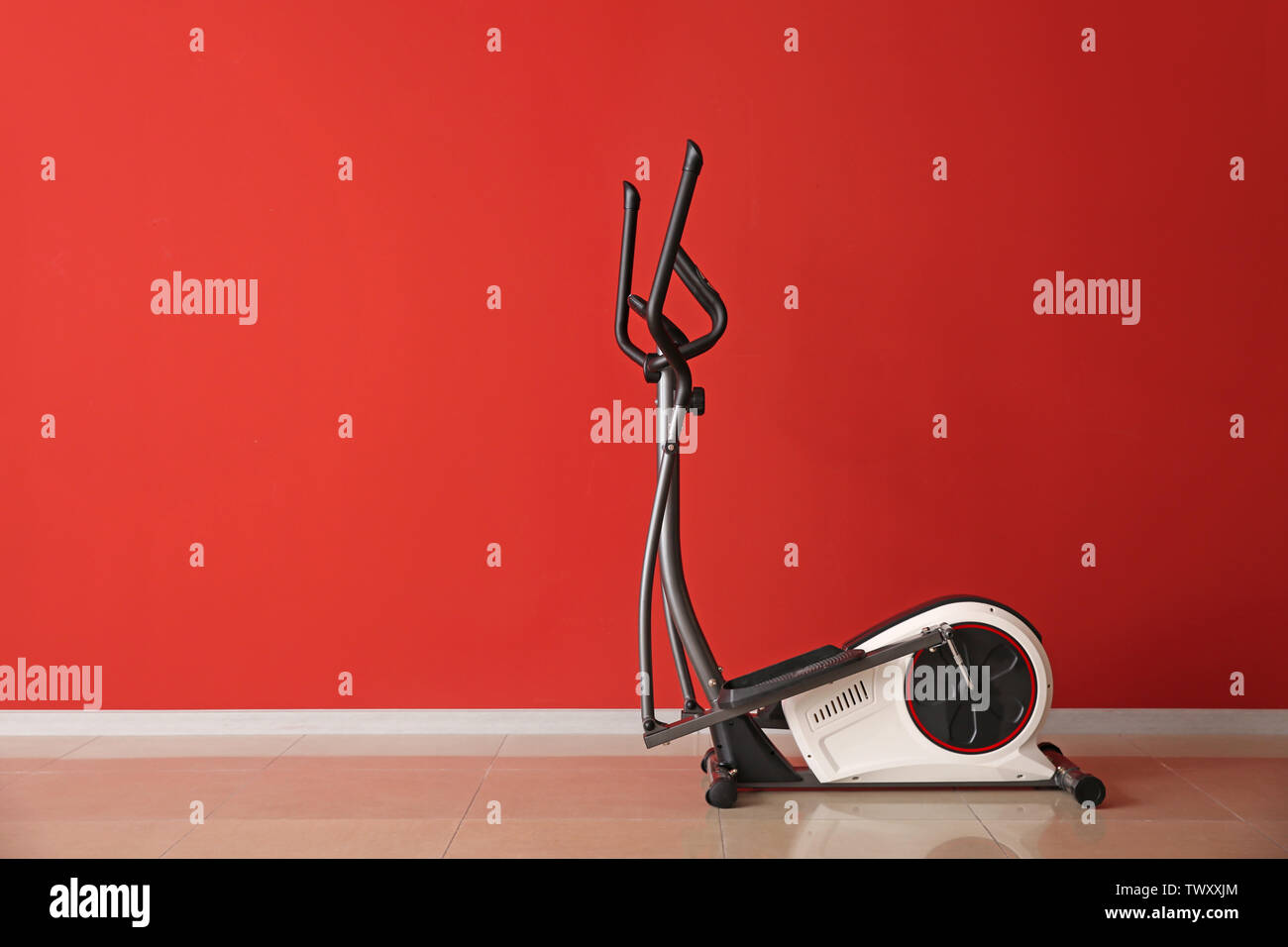 Modern exercise machine near color wall Stock Photo - Alamy