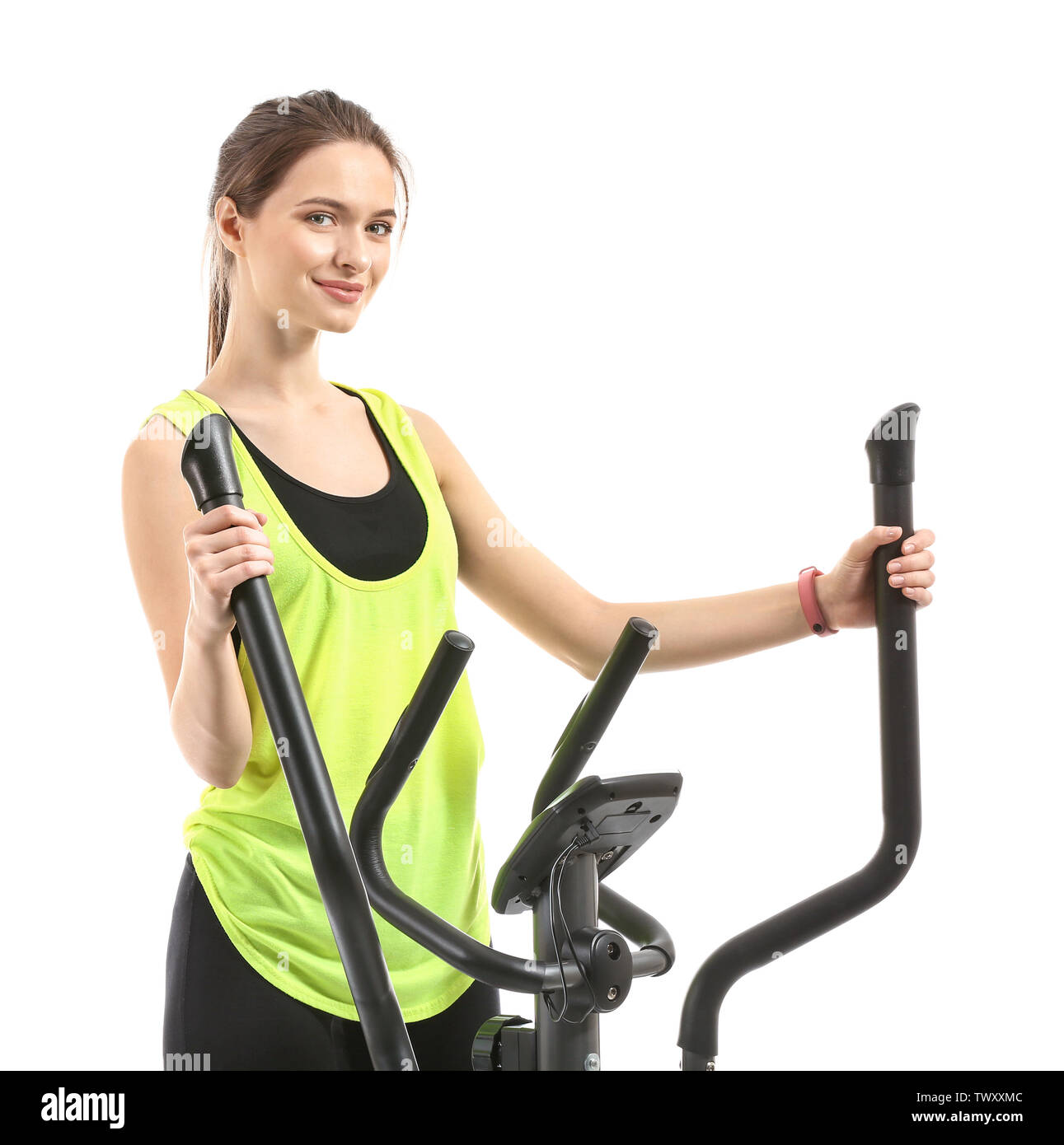 Sporty young woman training on machine against white background Stock ...