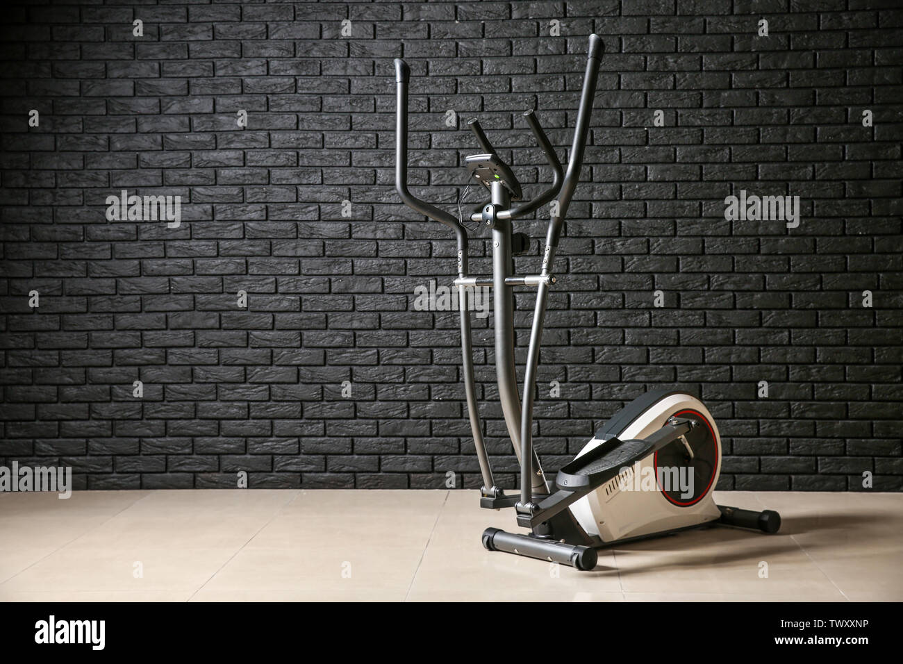 Modern exercise machine near dark brick wall Stock Photo - Alamy
