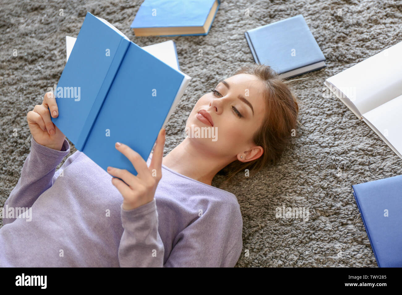 Female student reading books at home Stock Photo - Alamy