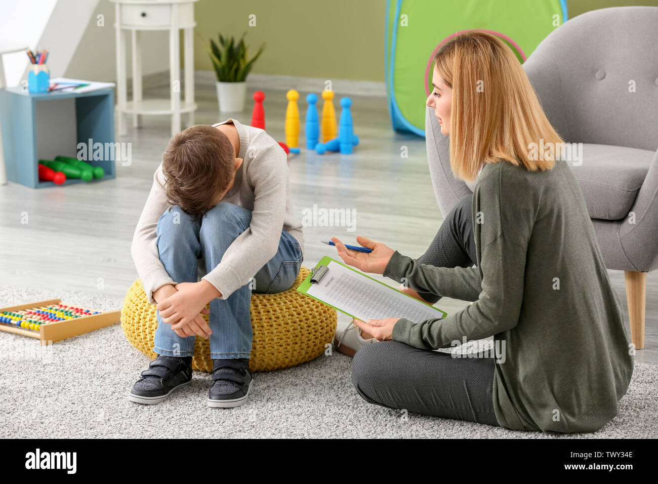 Female psychologist working with boy suffering from autistic disorder ...