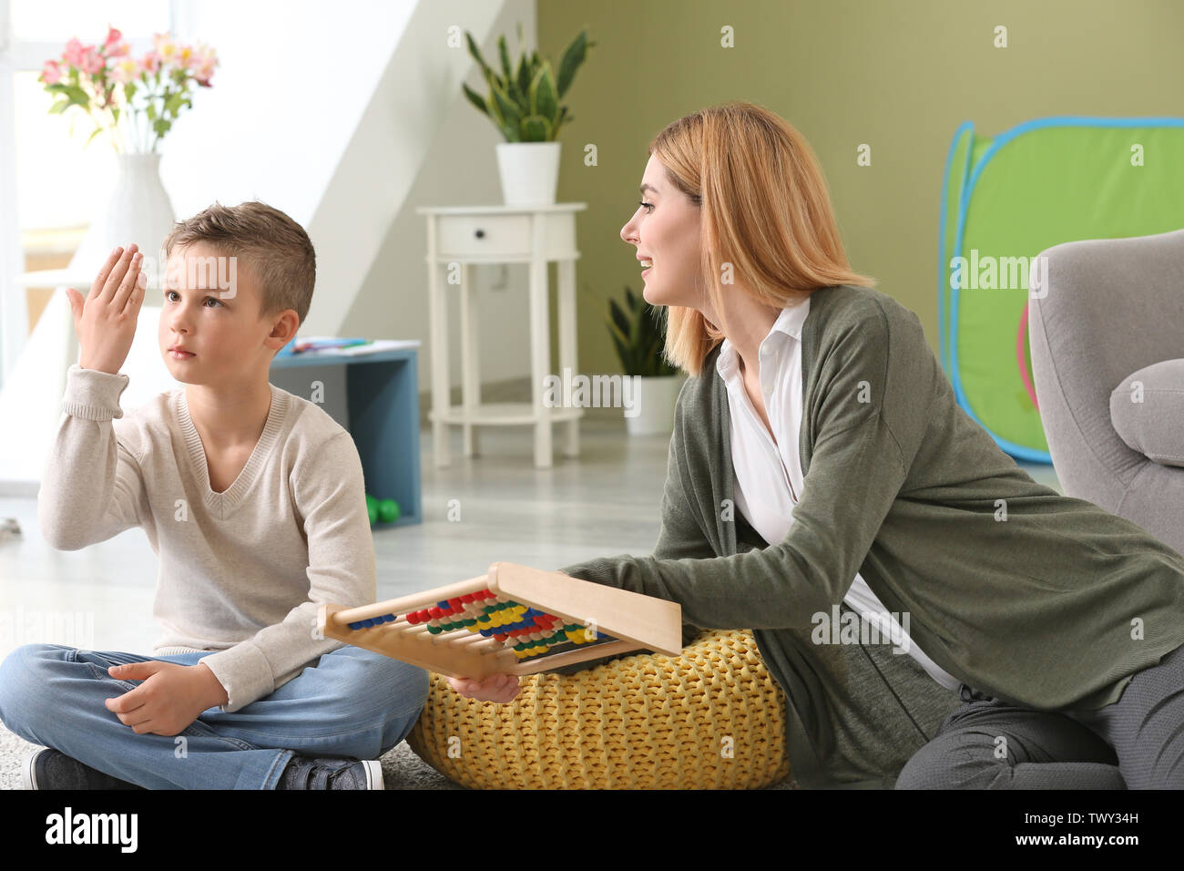 Female psychologist working with boy suffering from autistic disorder ...