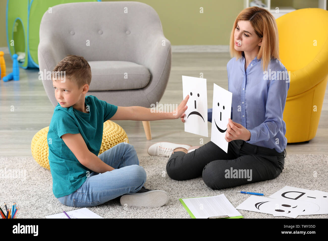 Female psychologist working with boy suffering from autistic disorder ...