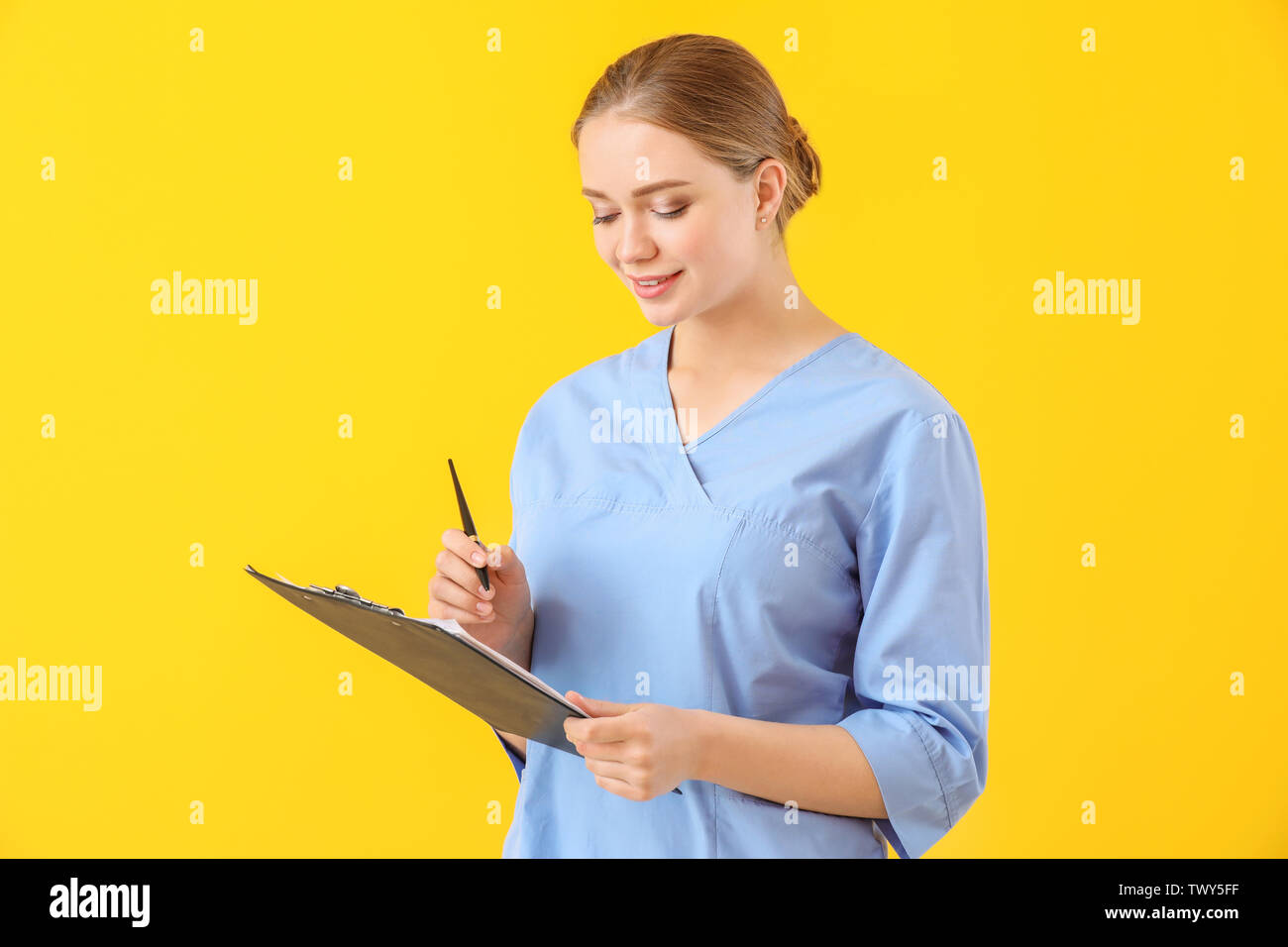 Young medical assistant with documents on color background Stock Photo ...