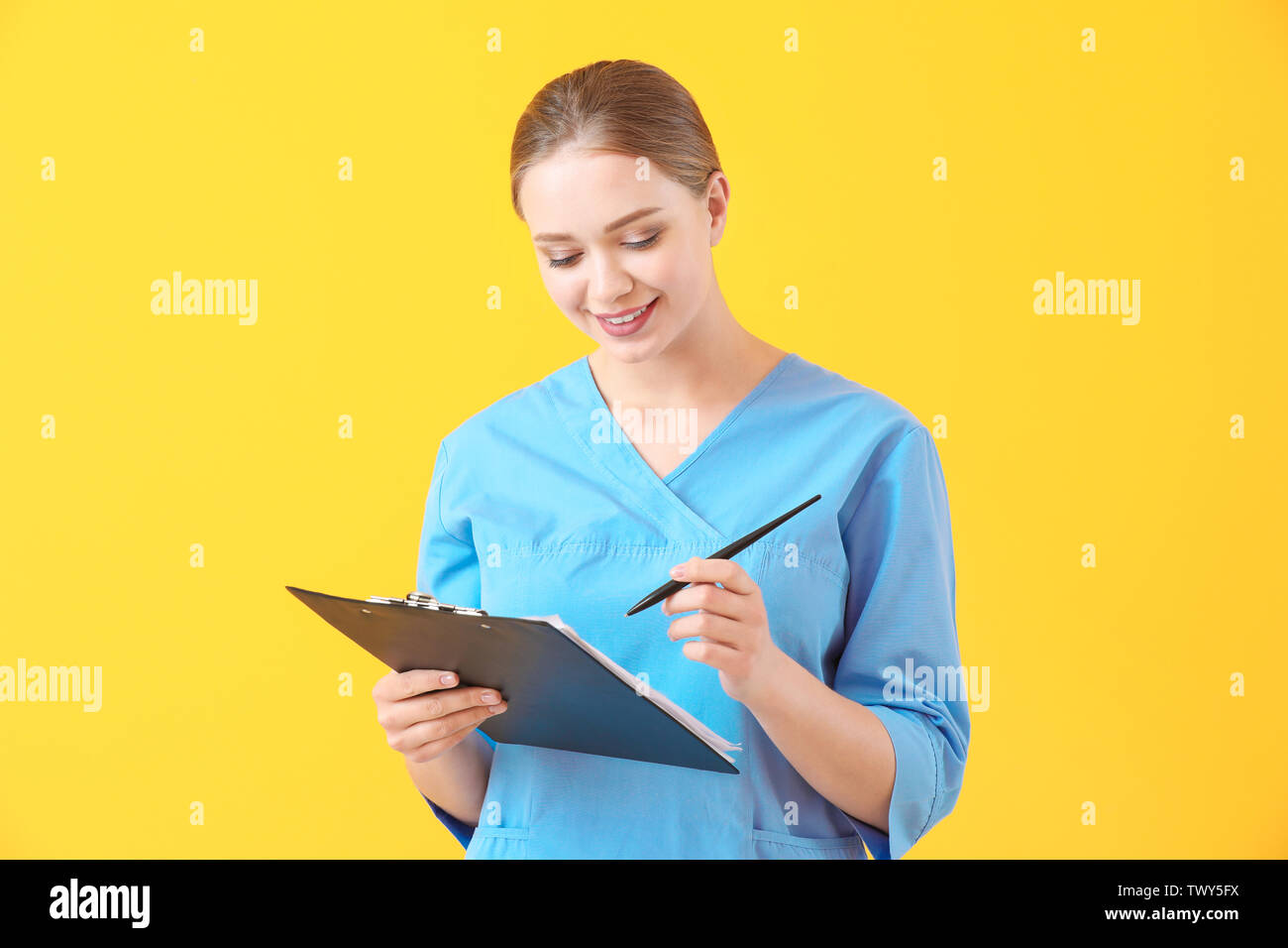 Young medical assistant with documents on color background Stock Photo ...